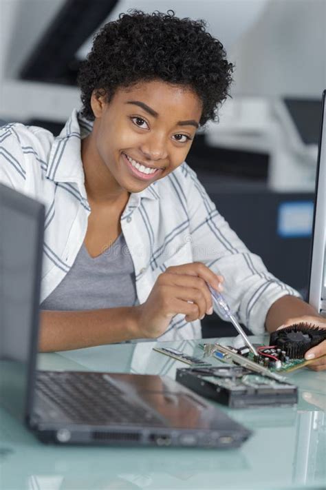 Young Female Electronic Engineer Soldering Computer Motherboard In Laboratory Stock Image
