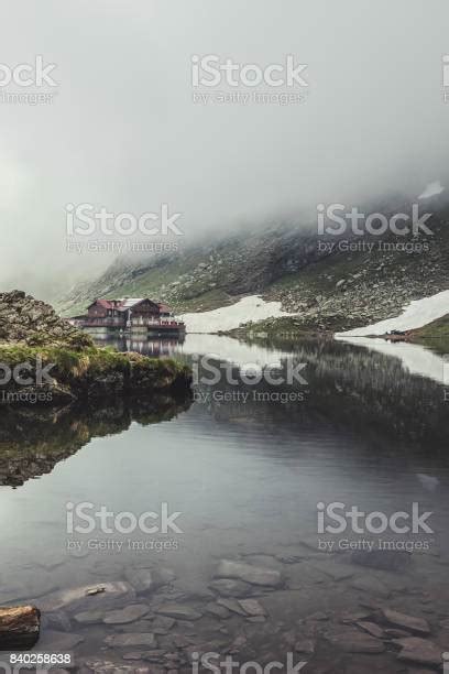 집에와 놀라운 빙하 호수 Balea 및 Carpathians 루마니아에서 물에 반영 하는 눈의 흰색 스트립과 Fagaras 산의