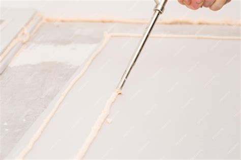 Premium Photo Applying Gluing Foam On Sheet Of Styrofoam Warming Of Floor In Residential