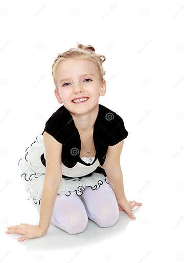 The Girl Kneeling On The Floor Smiling Directly Into The Camera Stock