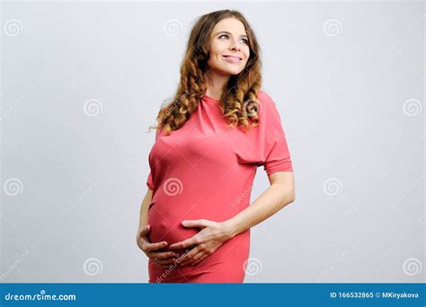 Beautiful Caucasian Pregnant Girl Touching Her Belly And Dreamily