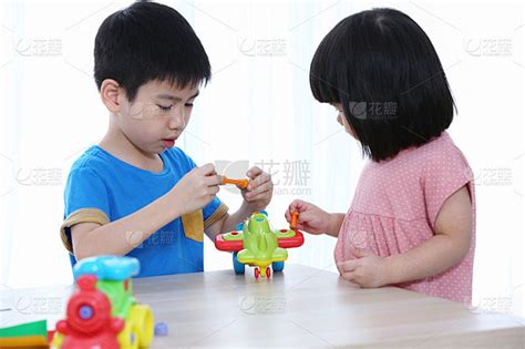 可爱的小男孩和小女孩正在用玩具飞机玩服务工具。使用玩具工具的蹒跚学步的孩子。一个工匠。