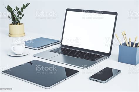 흰색 테이블 표면에 로고 또는 텍스트 디지털 태블릿 및 스마트 폰을위한 카피 스페이스가있는 빈 흰색 노트북 화면이있는 현대적인 작업 공간에 대한 원근감보기 3d 렌더링 모형