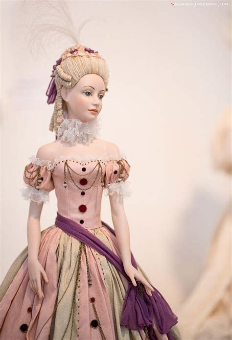 A Mannequin Wearing A Pink Dress And Purple Ribbon Around The Waist In Front Of A White Wall