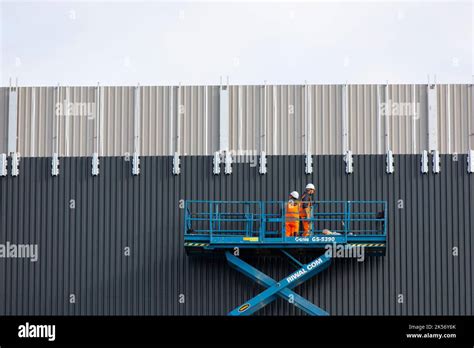 Worked Installing Cladding On Industrial Building Using Scissor Lift