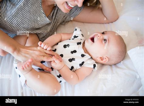 Caucasian Mother And Baby Daughter Laying On Bed Stock Photo Alamy