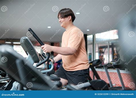 A Man Is Smiling While Riding A Stationary Bike In A Gym Stock Image