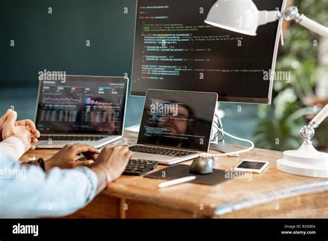 Programmierer Ein Programm Zu Schreiben Code Am Arbeitsplatz Sitzen Mit Drei Monitoren Im B Ro