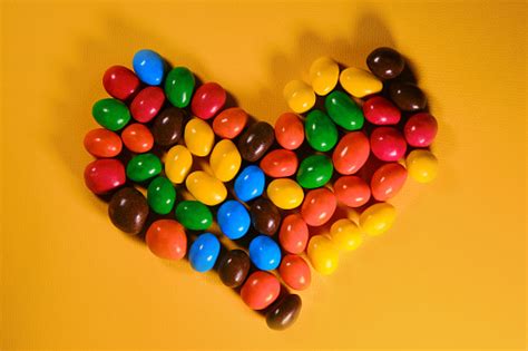 발렌타인 데이의 개념입니다 위에서 본 모습 플랫 레이 인사말 카드 화려한 달콤한 사탕이 하트 모양으로 배치됩니다 노란색