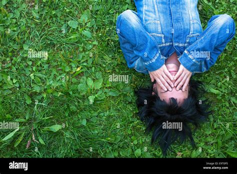 Girl In A Denim Jacket Lying On The Grass With Space For Text Stock