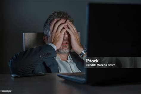젊은 절망과 스트레스 사업가 사무실 노트북 컴퓨터 책상 불안 및 우울증 문제 및 불안 위기 비즈니스 문제에 고통을 압도 느낌에 초과 근무 가리기에 대한 스톡 사진 및 기타
