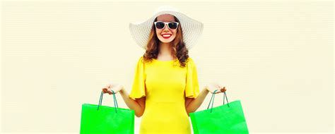 도시에서 노란색 드레스와 여름 밀짚 모자를 쓰고 화려한 쇼핑백을 가진 아름다운 행복한 젊은 여성 세일에 대한 스톡 사진 및 기타
