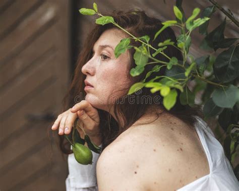 Portrait Of A Young Woman In Profile With A Pear In Her Hands Stock