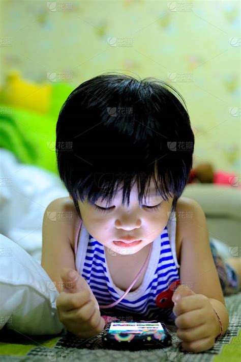 可爱的亚洲孩子玩智能手机游戏