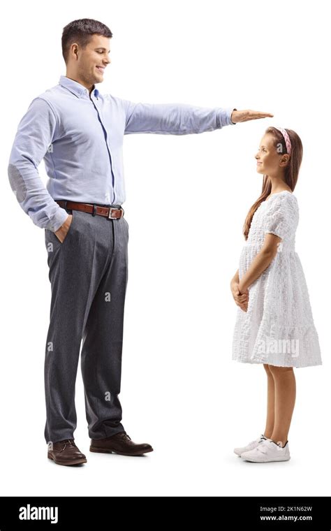 Full Length Shot Of A Father Measuring His Daughter Isolated On White