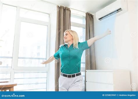 Women Enjoy The Coolness While Standing In Front Of The Air Conditioner
