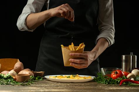 요리사는 봉투에 소금을 튀김 야채와 배경에 준비 프랑스 맛 있는 하지만 해로운 음식 요리 배경 디자인 및 메뉴 집에서 만든 레시피 요리 책 패스트 푸드 요리사에 대한 스톡