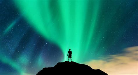 오로라 그리고 산의 정상에 혼자 서 있는 남자의 실루엣 Lofoten 섬 노르웨이입니다 오로라 보 리 얼 리스 고 젊은