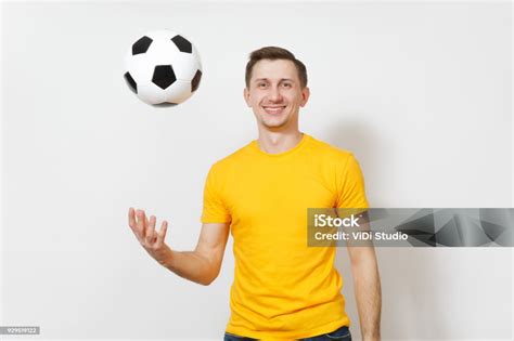 영감 을된 명랑 유럽 젊은이 팬 또는 축구 공 위로 노란색 유니폼 던져에 선수 흰색 배경에 고립 좋아하는 축구 팀을 응원 합니다