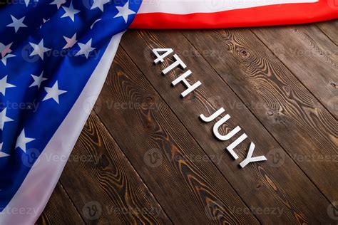 The Words 4th July And Crumpled Usa Flag On Flat Textured Wooden