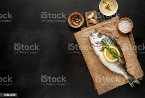 신선한 원시도 라도는 돌 배경에 향신료와 올리브 오일을 사용 하 여 절단 보드에 물고기 텍스트 공간 로즈마리에 대한 스톡 사진