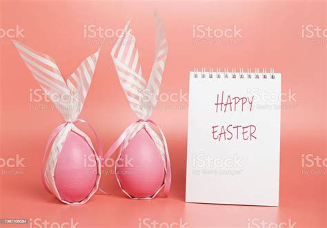 분홍색 달걀 두 개가 부활절 토끼의 형태로 종이로 싸여 있습니다 비문 해피 부활절 노트북 부활절 준비 계절에 대한 스톡 사진 및 기타 이미지 Istock