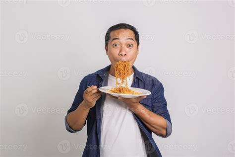 Asian Man Eating A Lot Of Instant Noodles And Feel Surprise With How