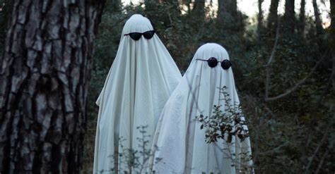 View Of People Dressed As Ghosts Wearing Sunglasses Standing In A