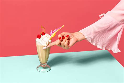 커피와 휘핑 크림 밝은 분홍색 배경에 고립 된 아일랜드 커피로 높은 유리를 만지는 여성의 손 트렌디 한 색상 팝 아트 복고풍