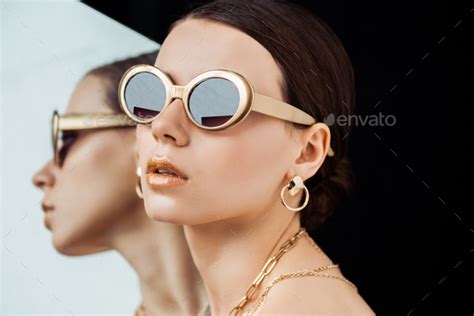 Young Naked Woman In Sunglasses Golden Jewelry Near Mirror Isolated On