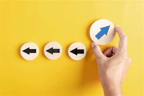 Hand Holding Blue Arrow And Different Direction Facing Opposite
