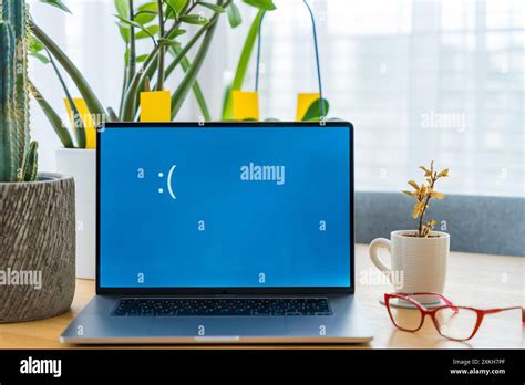 Sad Laptop Monitor With Blue Screen Error On Home Office Desk With