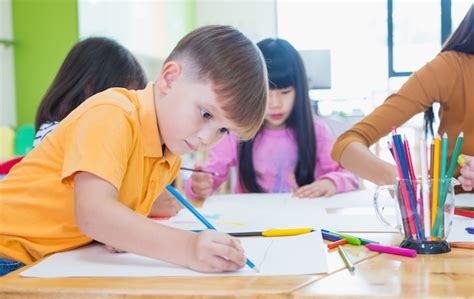 Niños preescolares dibujando con lápiz de color sobre papel blanco en