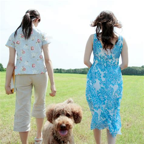 草原を歩く2人の女性と犬 20027001298 の写真素材・イラスト素材｜アマナイメージズ