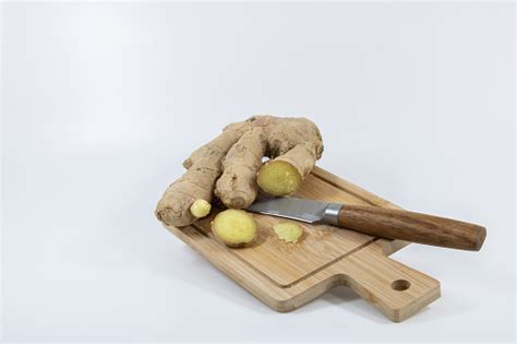 흰색 배경에 칼로 도마에 자른 신선한 생강 뿌리 줄기와 생강 조각 가루로 빻은에 대한 스톡 사진 및 기타 이미지 가루로 빻은 감기와 독감 건강관리와 의술 Istock