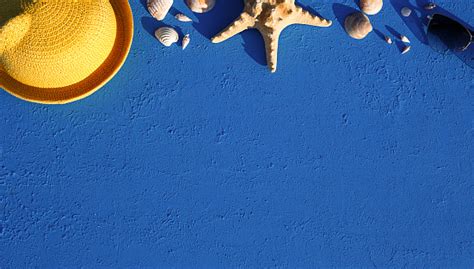 노란색 밀짚 모자 선글라스 불가사리 푸른 배경의 조개 등 해변 액세서리가 있는 프레임 휴가 개념 바다 여행 자외선 차단 수영 공간을 복사합니다 플랫레이 갑각류에 대한 스톡