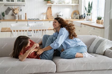 Premium Photo Mother And Teen Girl Daughter Enjoying Time At Home Tickling Each Other And Laughing