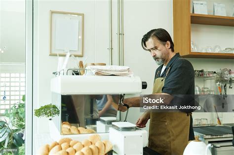 카페 내 에스프레소 머신에서 정교하게 커피를 끓이는 성인 남성 바리스타 장인의 열정과 헌신을 보여주며 가정커피사업 중소기업의 매력을 반영 45 49세에 대한 스톡 사진 및