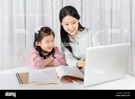 Asian Korean Mother And Daughter Taking Online Classes On Laptop Stock