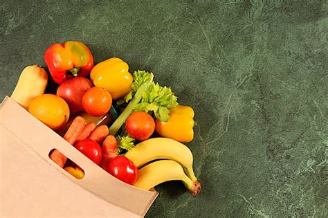 체중 감량을 위한 건강한 비건 제품이 포함된 캔버스 에코 백 레몬 오렌지 토마토 사과 바나나 당근 셀러리 및 천연 주스를 천 가방에 담아 음식 배달 컨셉 매장 광고 0명에