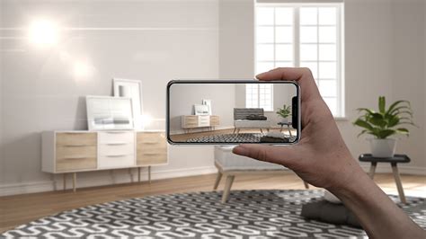 핸드 보유 스마트 폰 Ar 응용 프로그램 실제 가정에서 가구 및 인테리어 디자인 제품을 시뮬레이션 건축가 디자이너 개념 흐림 배경 카펫과 미니멀 한 거실 가격에 대한 스톡