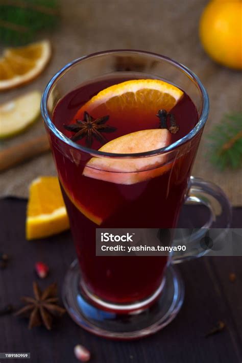 겨울 장식과 나무 배경에 오렌지 사과와 향신료 계피와 아니스 스타의 조각 멀드 와인의 유리 상단 보기 겨울과 가을의 뜨거운 음료