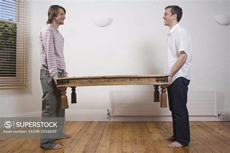 Gay Couple Lifting Table SuperStock