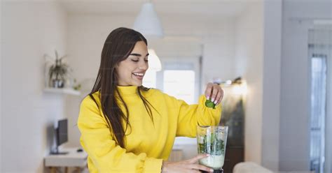 집에서 해독 스무디를 만드는 젊은 여성 과일과 채소의 스무디를 만드는 소녀 건강한 삶의 방식 믹서기를 사용하여 스무디를 만드는 행복한 소녀 사진 Unsplash의