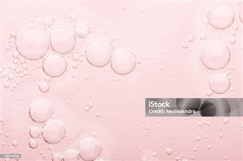 분홍색 배경에 보습 세럼의 투명한 질감 스킨케어용 젤 워터 로션 얼굴과 바디 스킨 케어용 레티놀과 비타민이 함유된 화장품 리퀴드