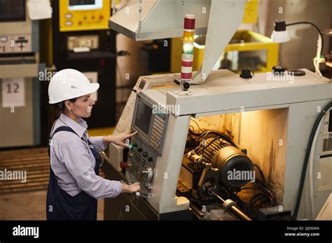 Serious Busy Female Technical Engineer Standing At Cnc Lathe And