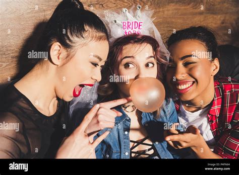 Fiance Blowing Bubble Gum While Having Fun With Multicultural Friends
