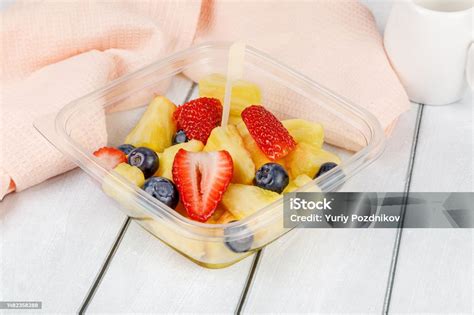파인애플 딸기 블루베리를 곁들인 과일 샐러드는 나무 배경에 플라스틱 용기에 담겨 있다 0명에 대한 스톡 사진 및 기타 이미지
