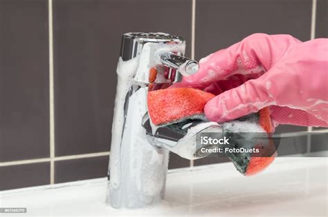 물 꼭지 세척 스폰지 고무 보호 장갑에 직원의 손 하 녀 또는 주부 집에 관심이 있다 봄 청소 일반 또는 일반 세척 위로입니다 상업적인 청소 회사 개념입니다 아파트에 대한