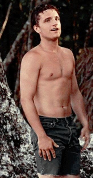 A Man Without A Shirt Standing In Front Of A Tree With His Hands On His